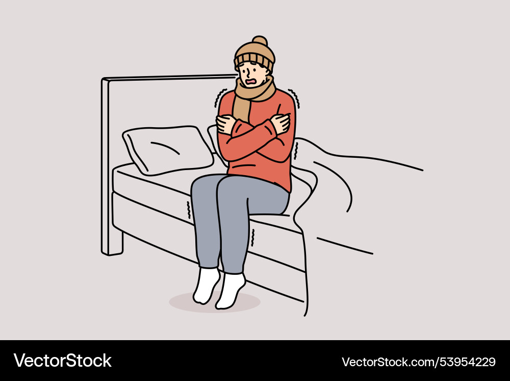 Freezing man is shaking sitting on bed and feeling