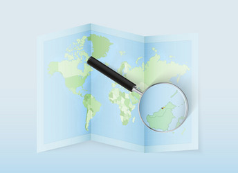 A folded world map with a magnifying lens Vector Image